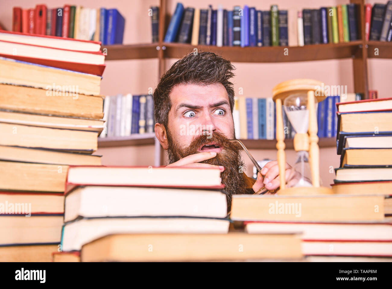 Man, scientist looks at hourglass. Man on serious and shocked face ...
