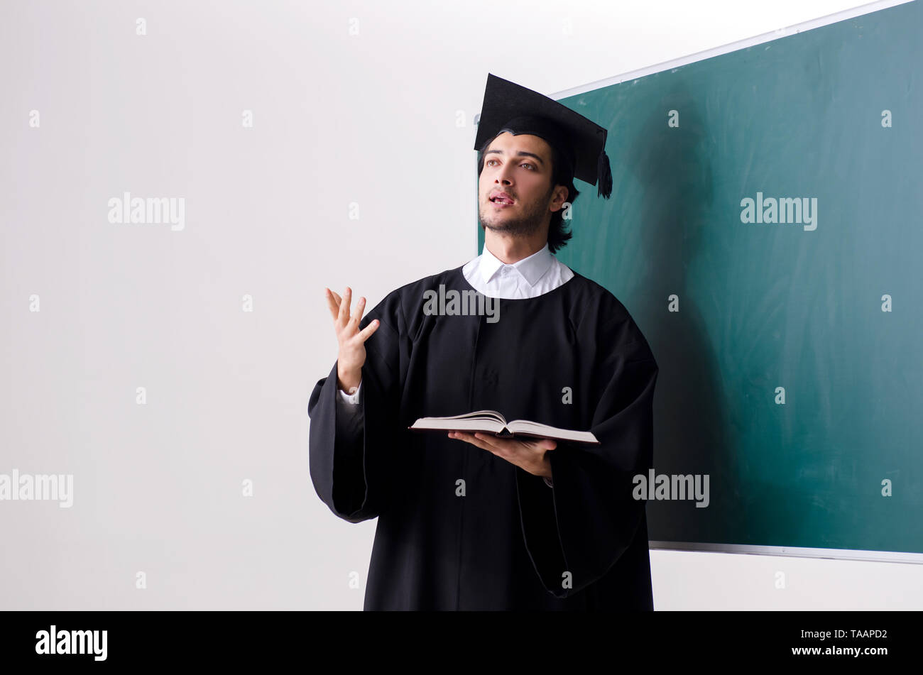 Graduate student in front of green board Stock Photo - Alamy
