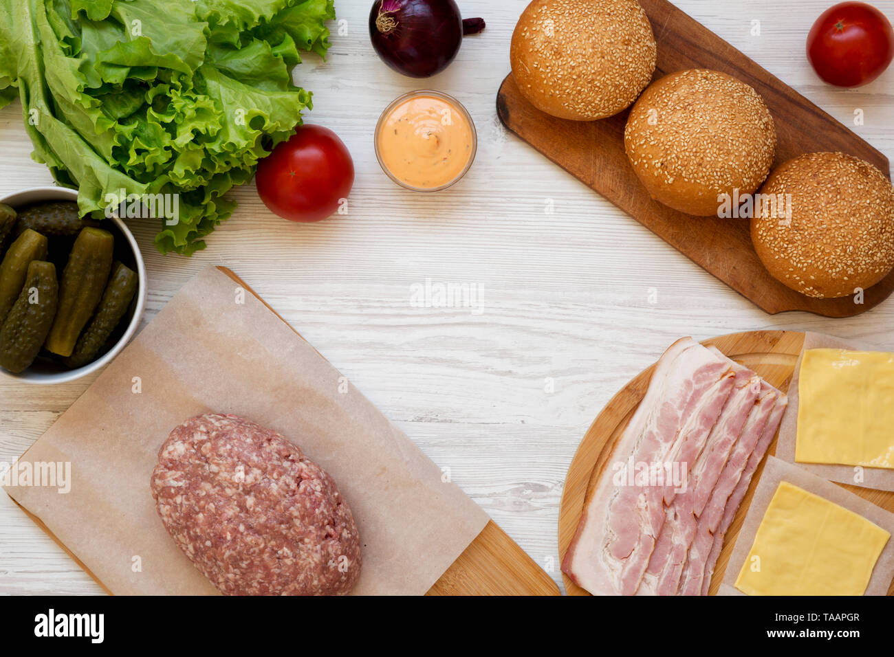 Cheeseburger ingredients on a white wooden background, top view ...