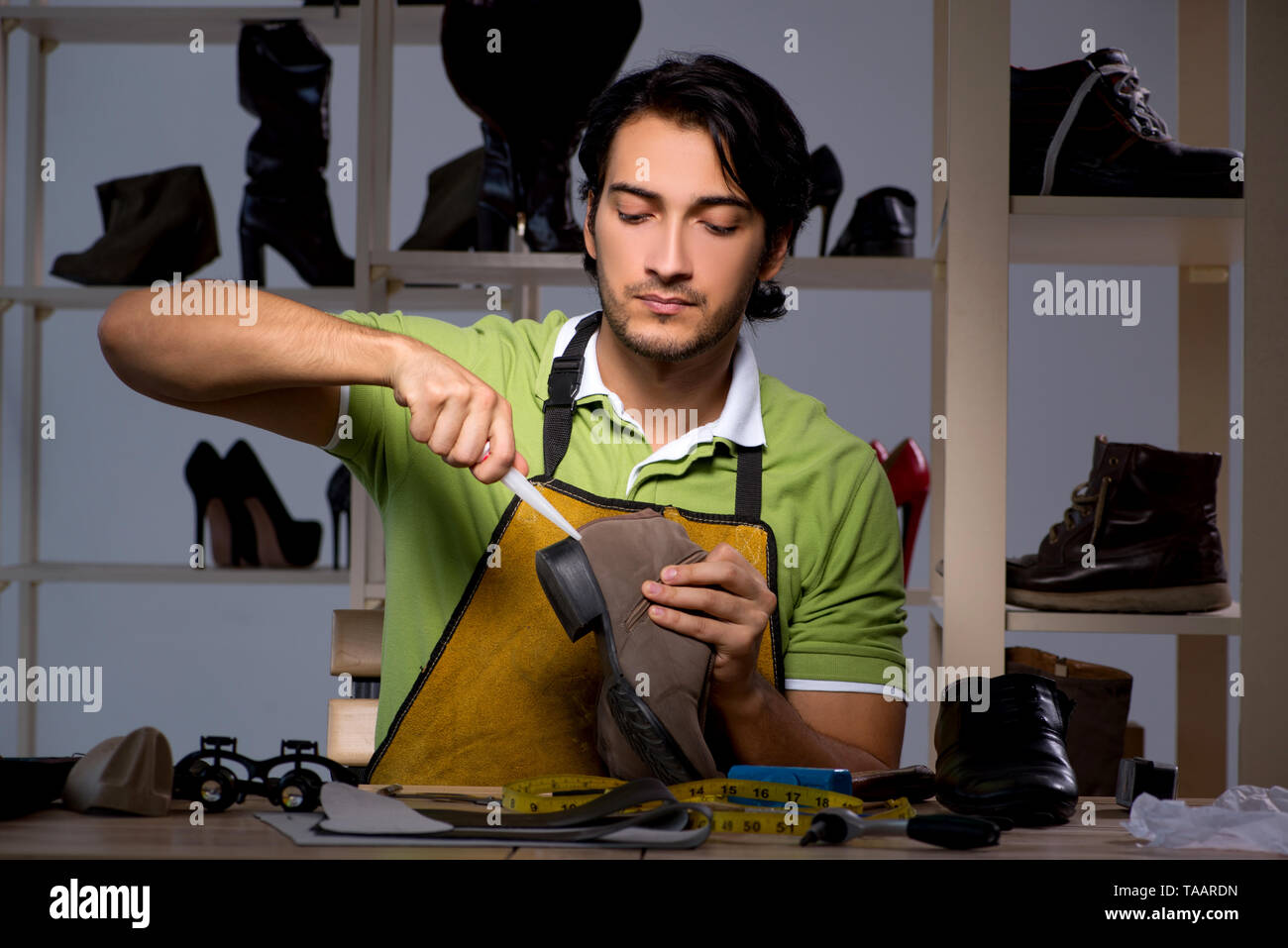 Young shoemaker in workshop at night Stock Photo - Alamy