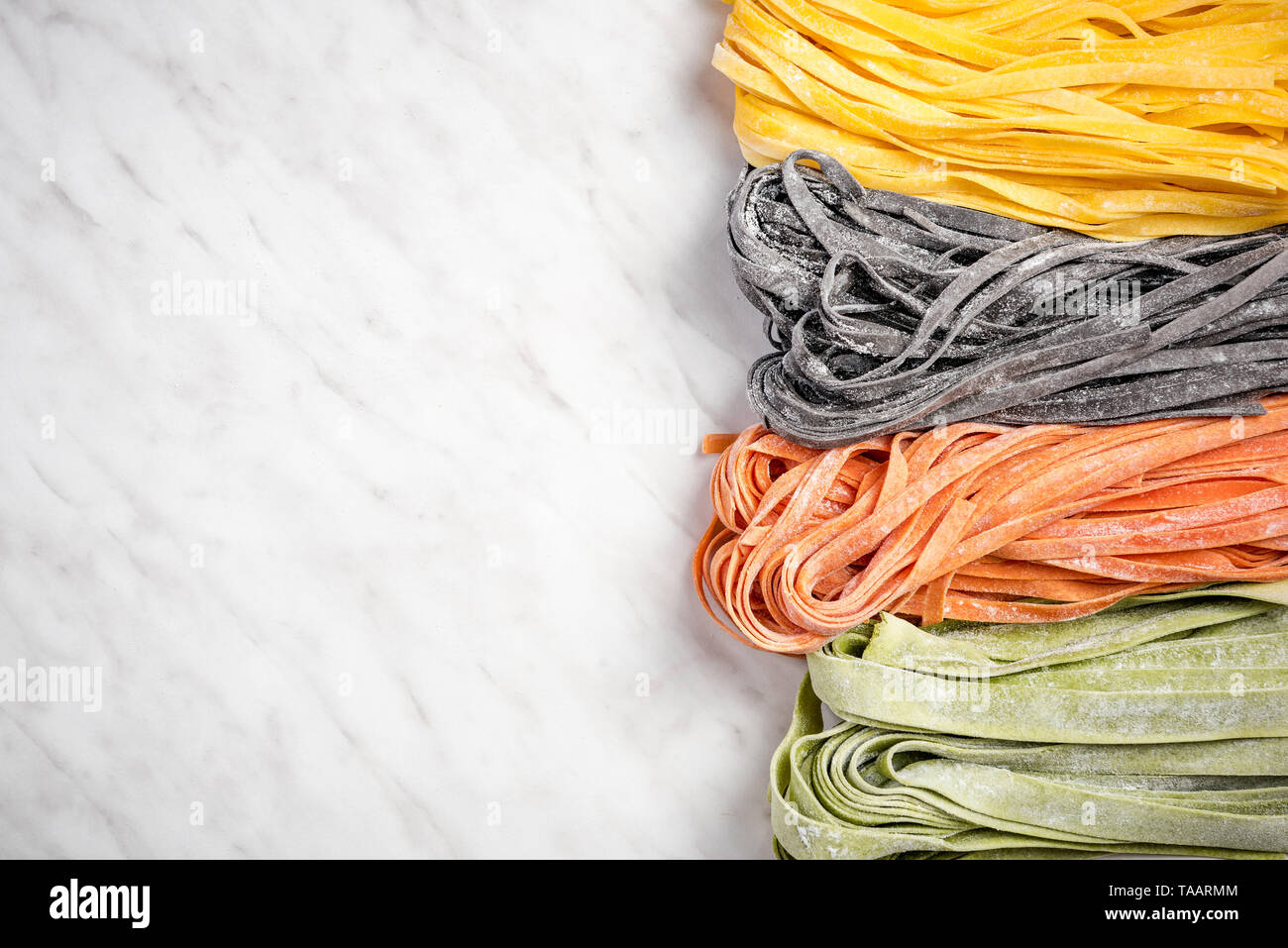 Variety of fresh raw homemade pasta. White marble background Stock ...