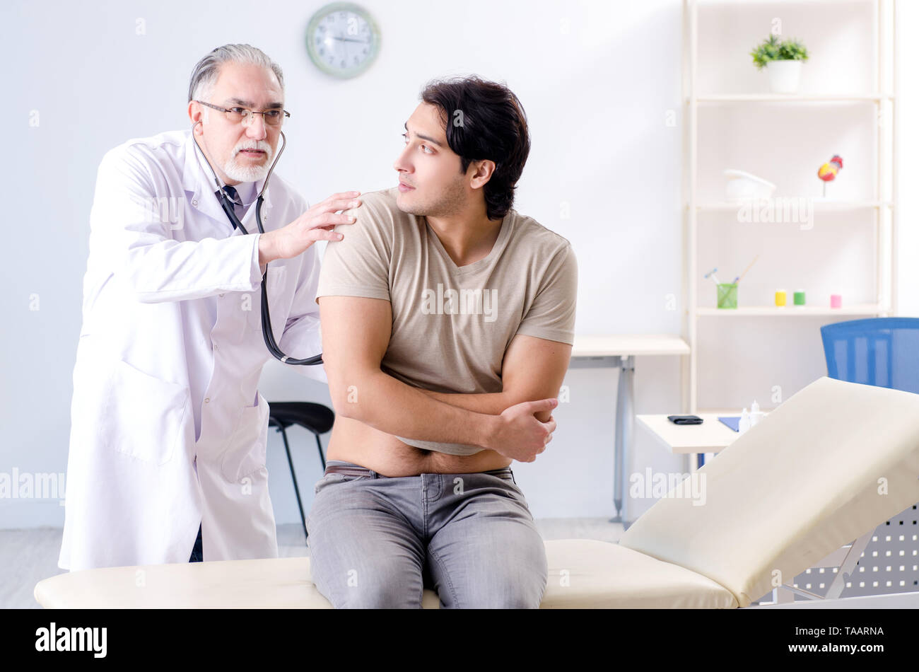 Young male patient visiting old doctor Stock Photo - Alamy