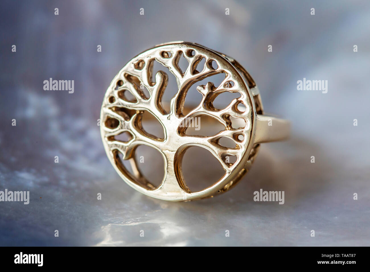 Brass metal ring in shape of treein mandala on pearl background Stock ...