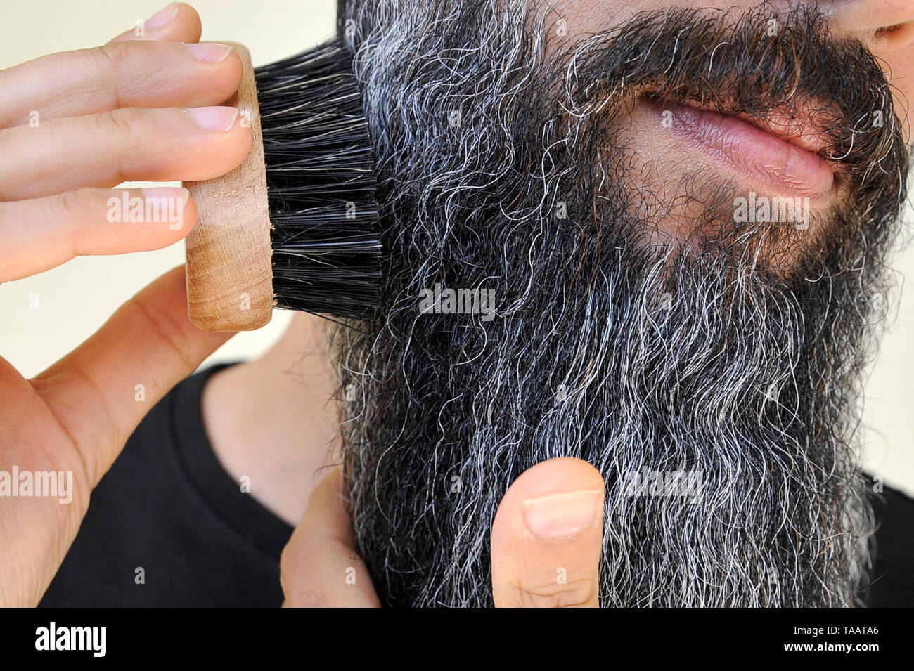 Italian hipster: hand brushing beard Stock Photo - Alamy