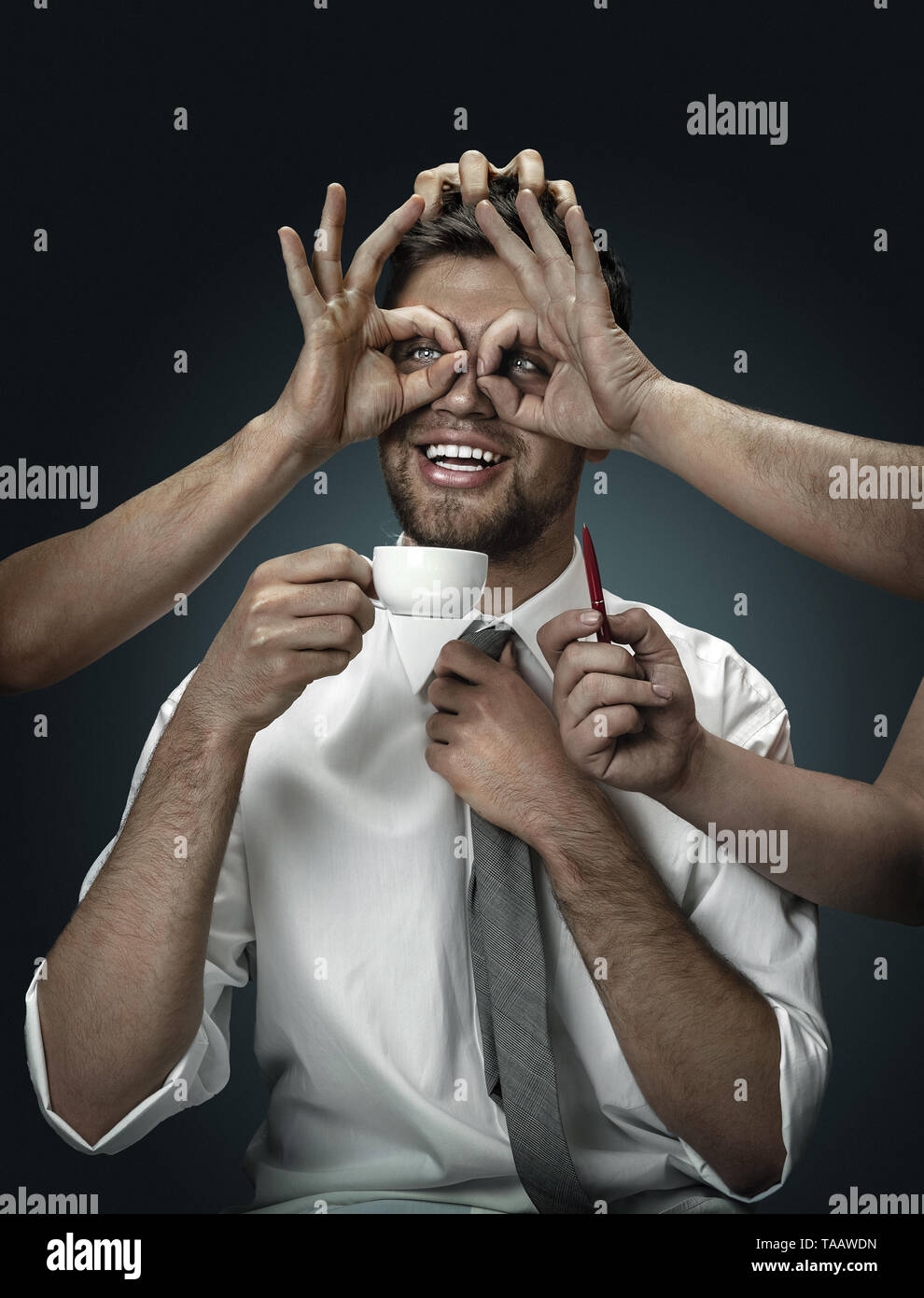 But first dinner. A male model surrounded by hands on dark background ...