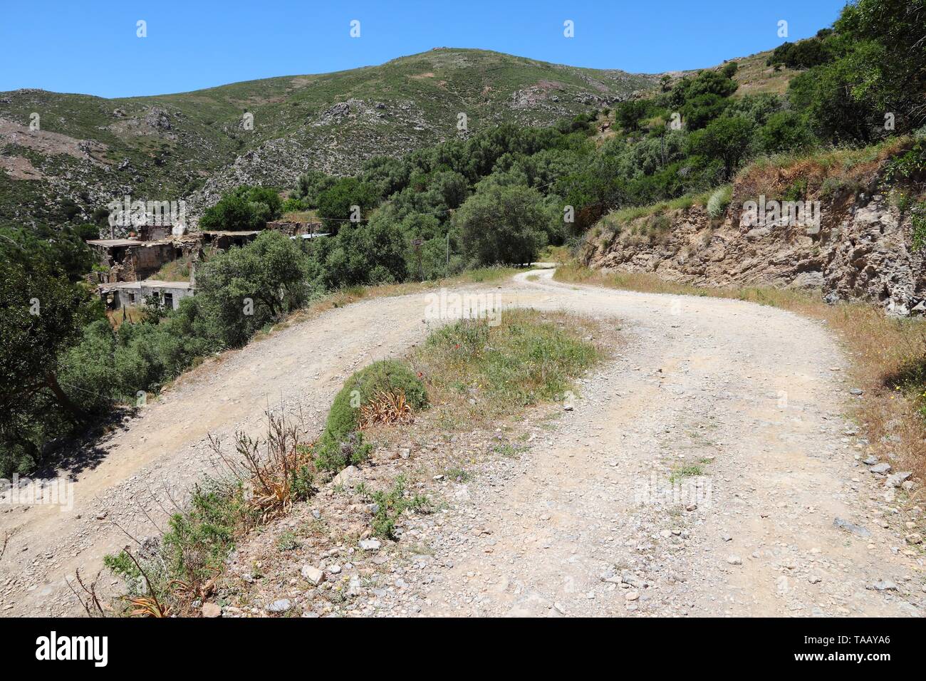 Landscape of Crete island. Gravel mountain road and abandoned village ...