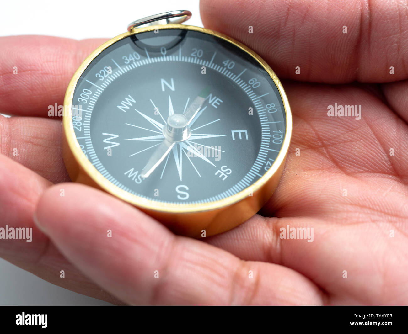 closeup man hand holding golden compass on white background (Isolated ...