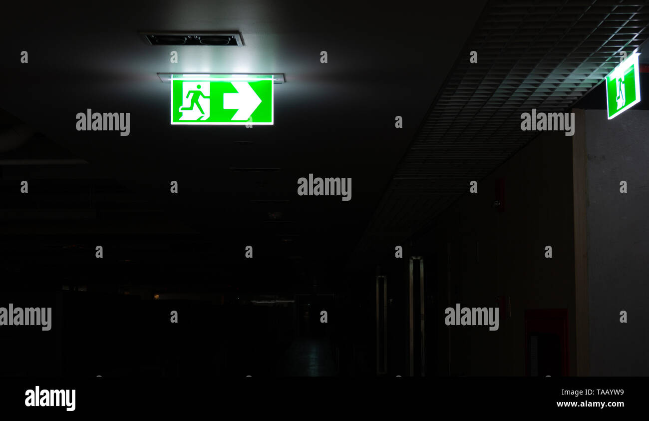 Green fire escape sign hang on the ceiling in the office at night Stock ...