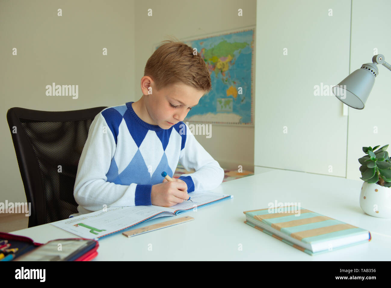 Intelligent boy makes homework at desk in his room Stock Photo - Alamy