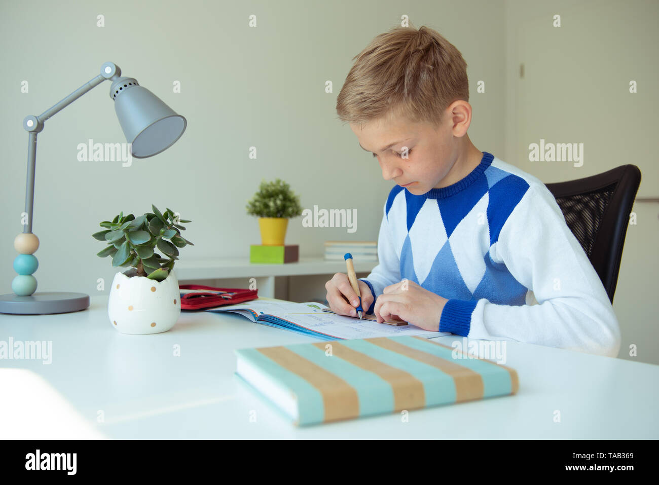 Intelligent boy makes homework at desk in his room Stock Photo - Alamy