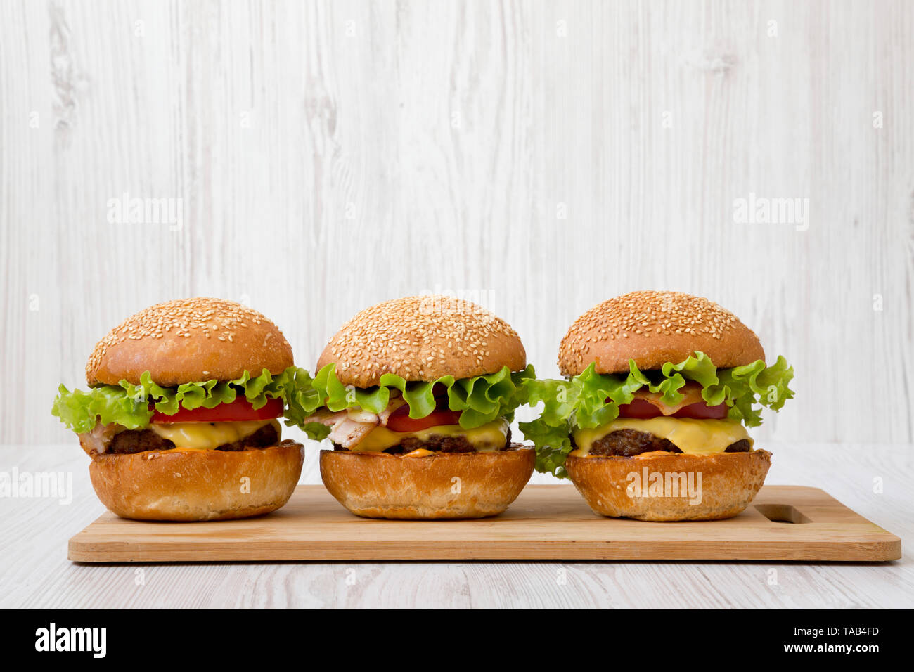 Homemade cheeseburgers on a bamboo board, side view. Close-up Stock ...