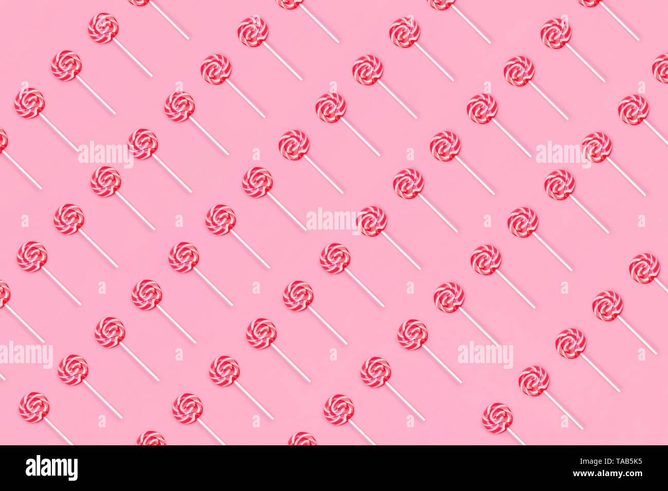 Pattern of colorful lollipop candy with stick on soft pink background ...