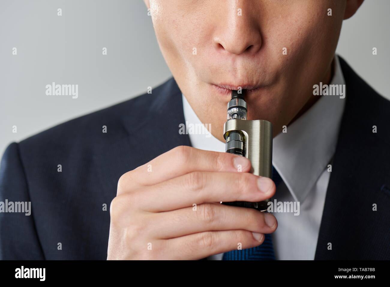 Young Japanese man smoking electronic cigarette Stock Photo - Alamy
