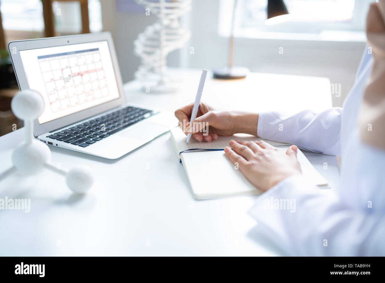 Checking schedule. Female scientist checking her schedule on laptop ...