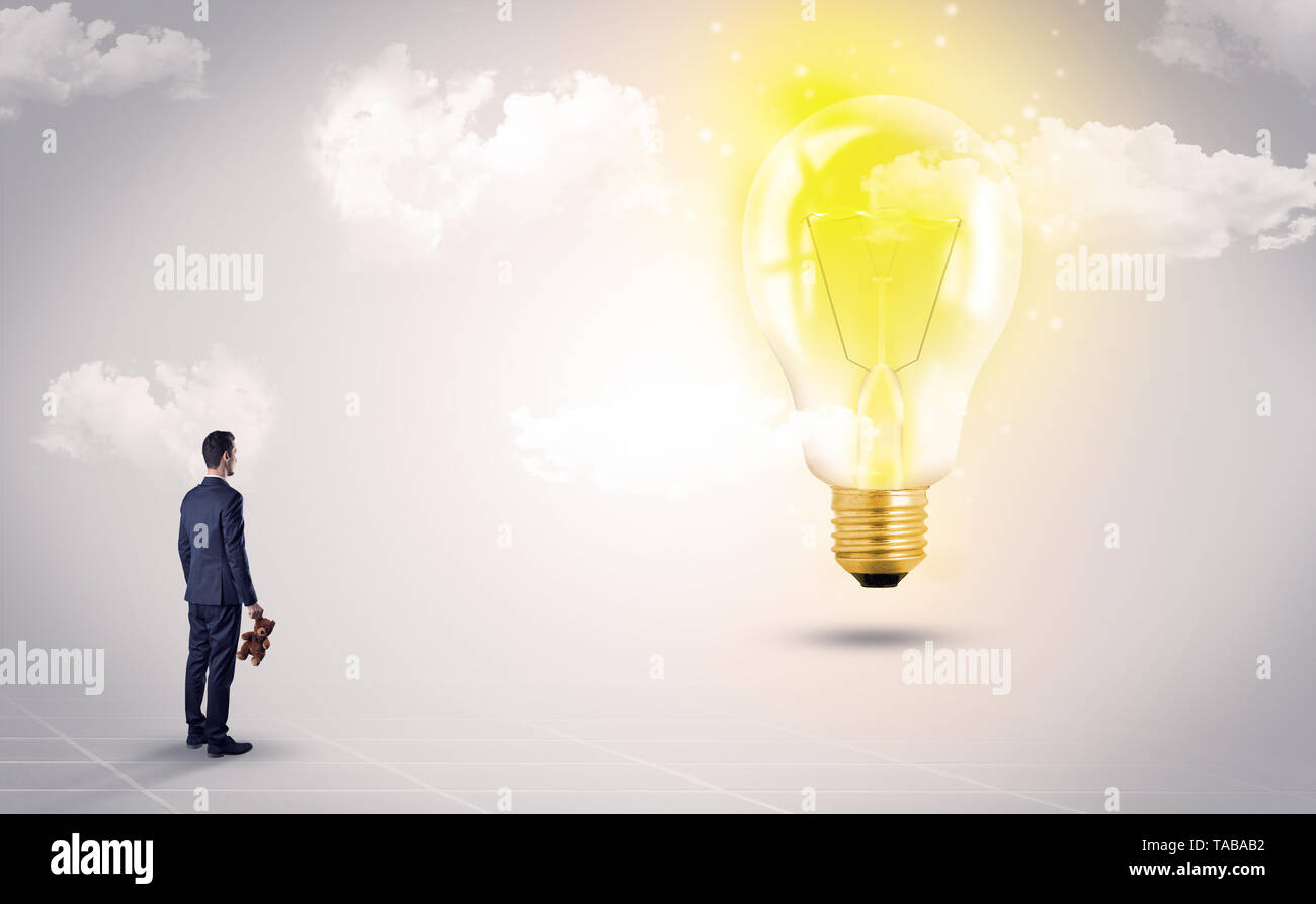 Businessman standing with his back with objects in his hand and looking ...