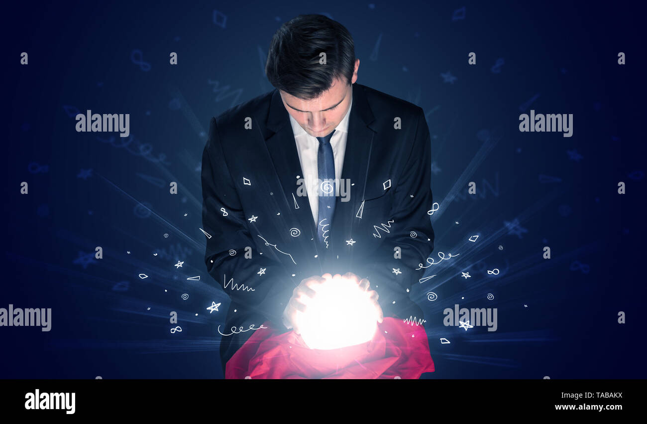 Gorgeous businessman looking to inspiration in a magic ball in his lap ...
