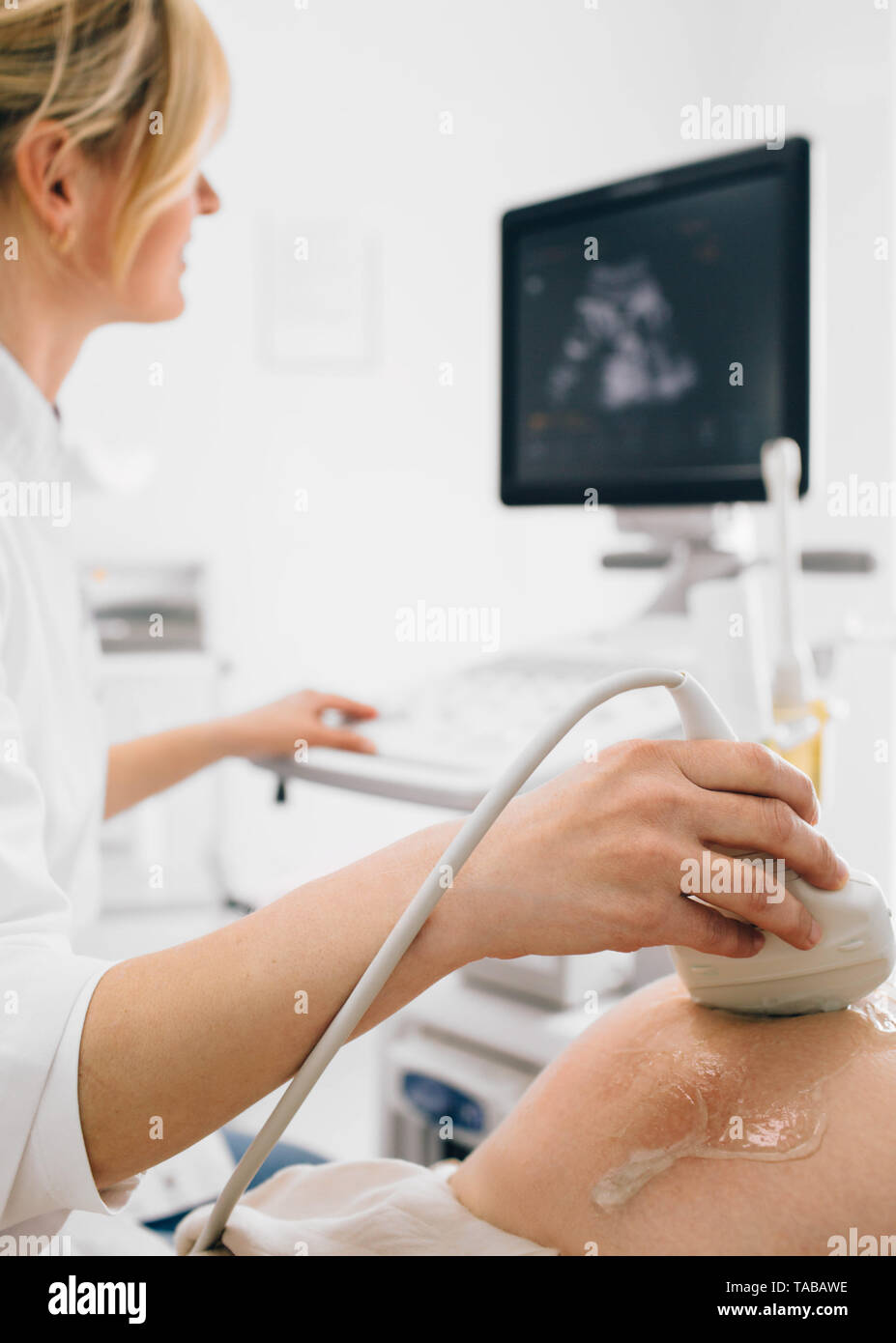 female doctor doing sonogram with pregnant woman at clinic. pregnant ...