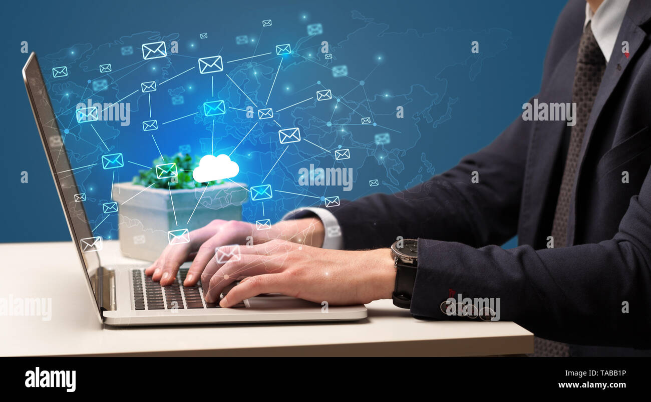Businessman hand sending a bunch of messages on laptop with cloud ...