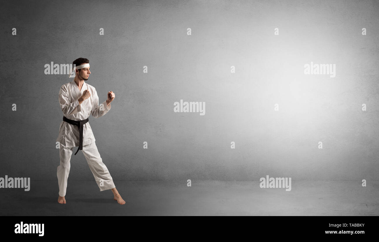 Small karate man fighting in an empty grey copy space Stock Photo - Alamy