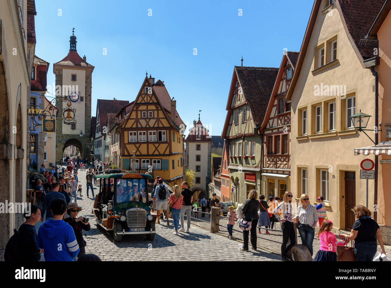 A shuttle bus driving through a busy Plönlein in Rothenburg ob der ...