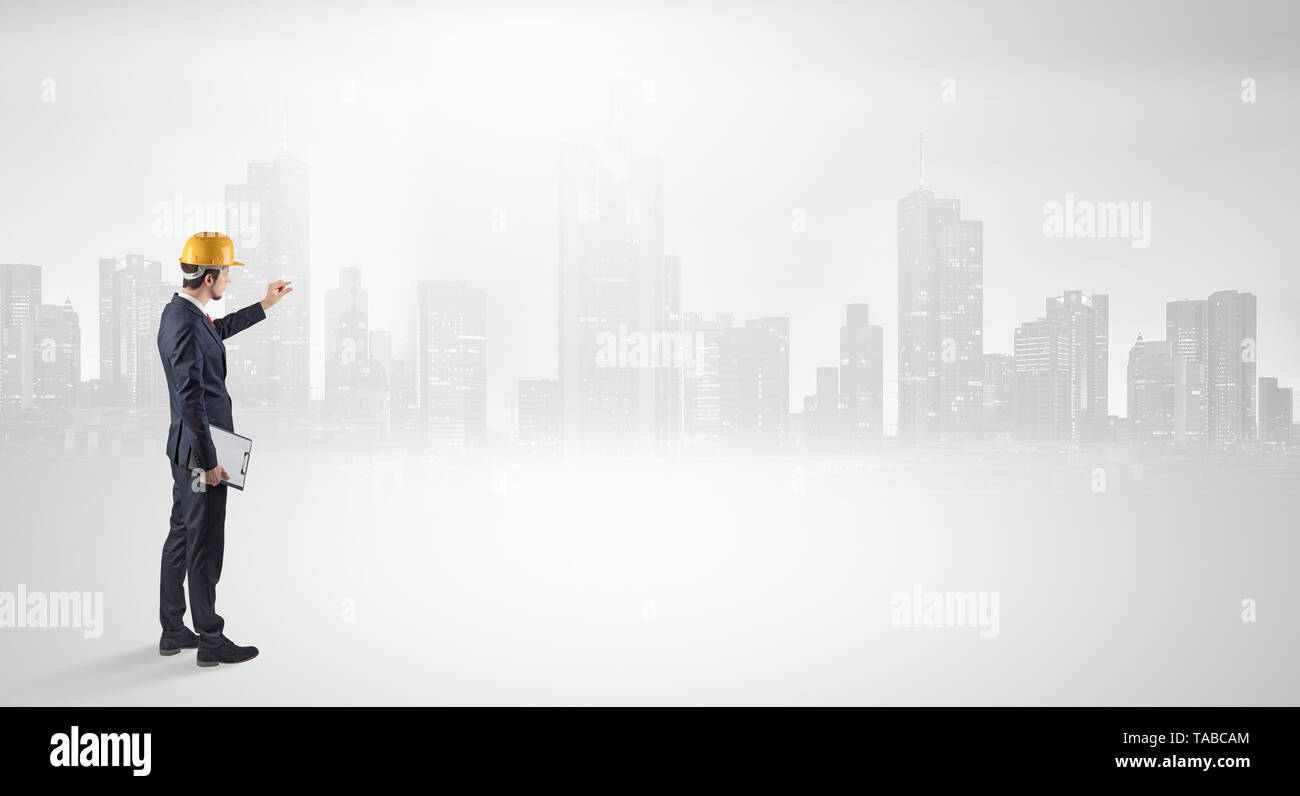 Young supervisor architect standing and looking at a big city panorama ...