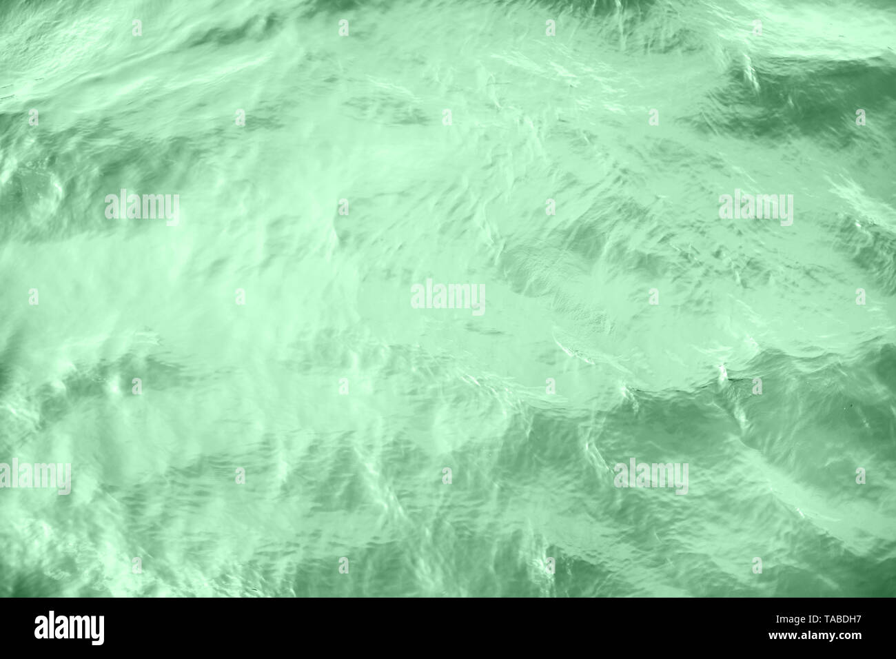 Closeup of calm river water surface with water splashes in neo mint ...