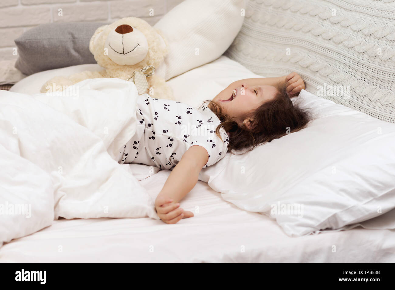 cute little child girl wakes up from sleep in bed in the morning Stock ...