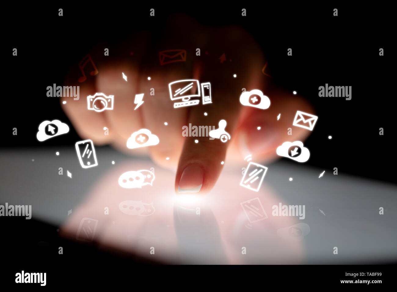 Finger touching tablet with white drawn application icons and dark ...