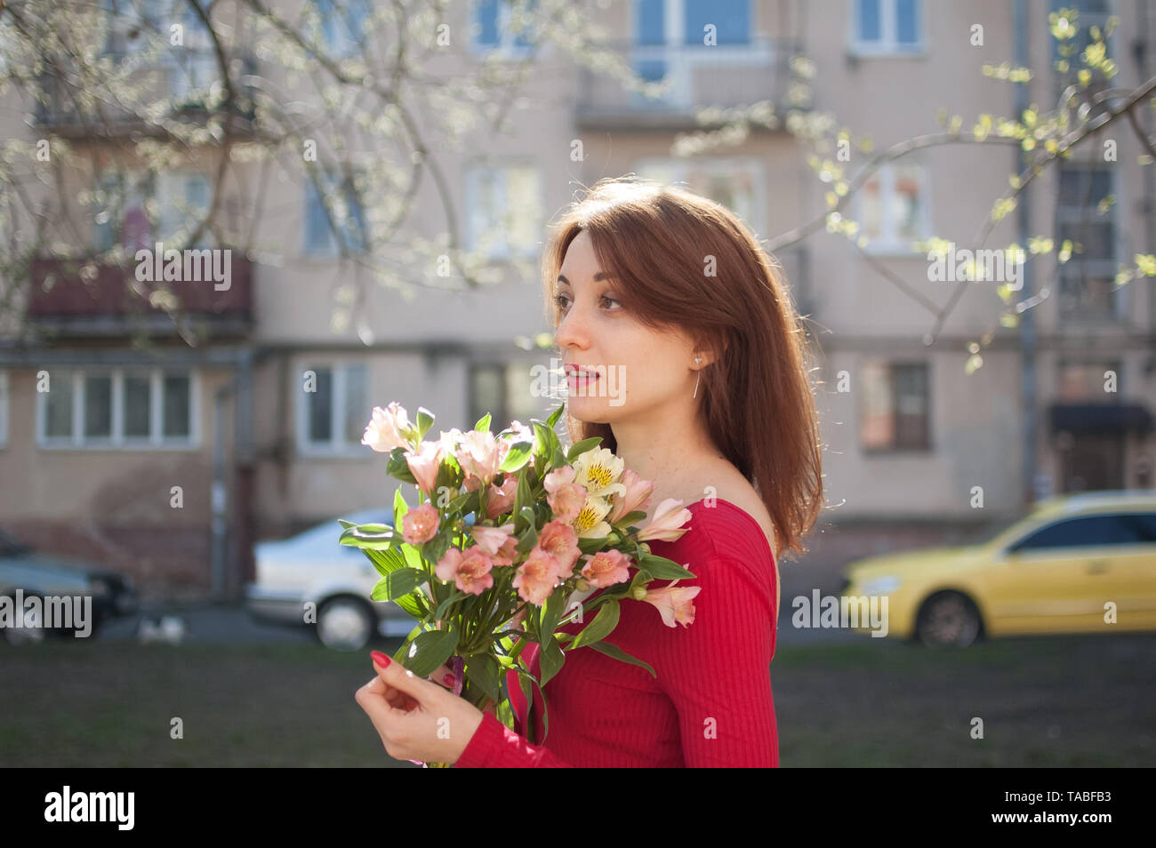 Attractive brunette girl is holding bouquet of colorful flowers ...