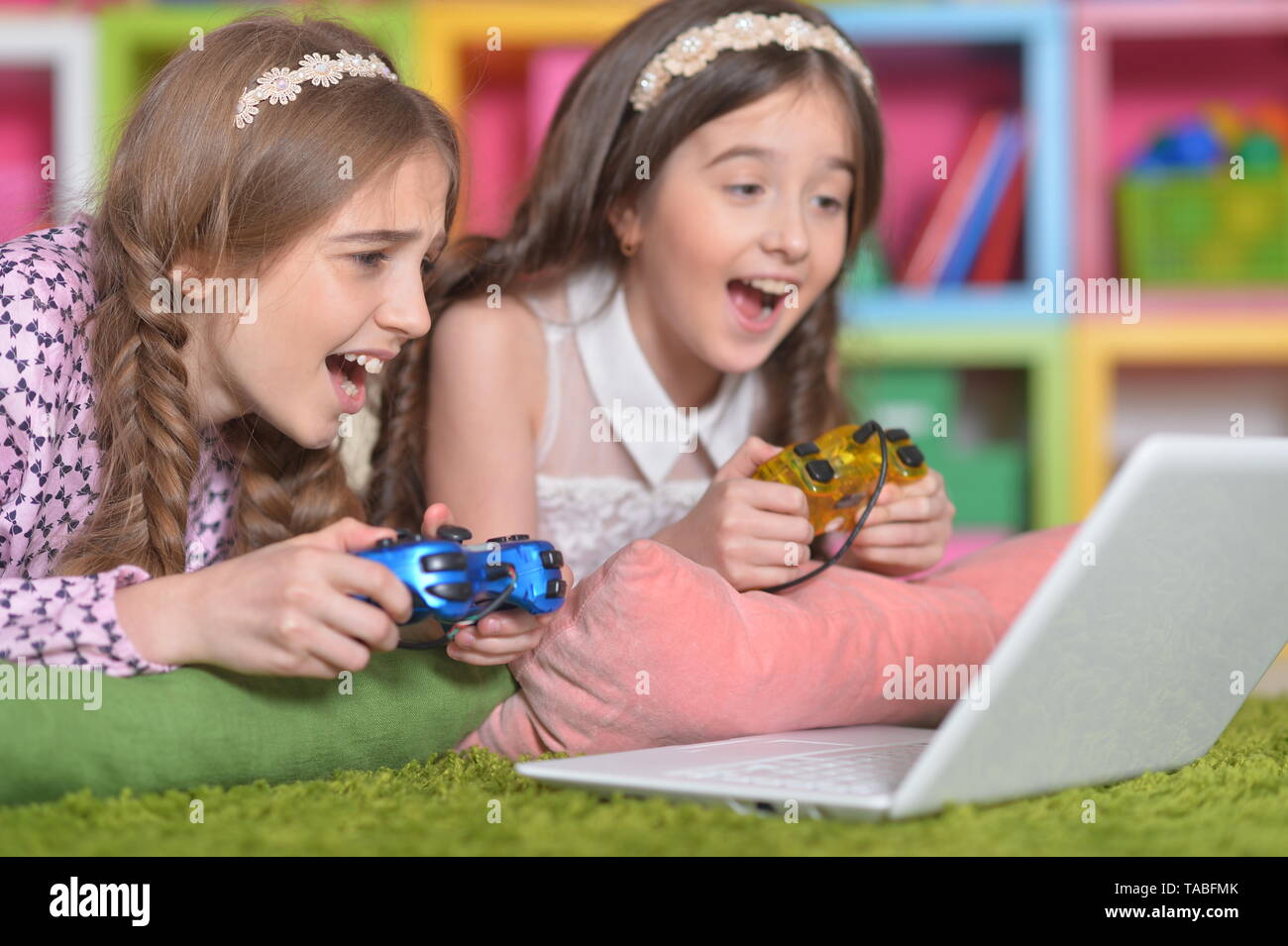 Portrait of adorable little girls playing computer game Stock Photo - Alamy