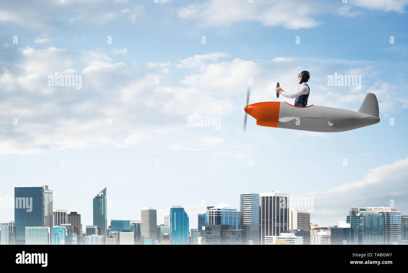 Businessman driving propeller plane above downtown Stock Photo - Alamy