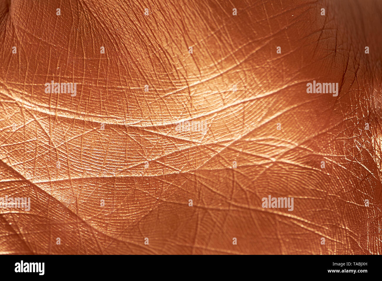 The texture of human skin, painted with gold paint. The palm with the ...