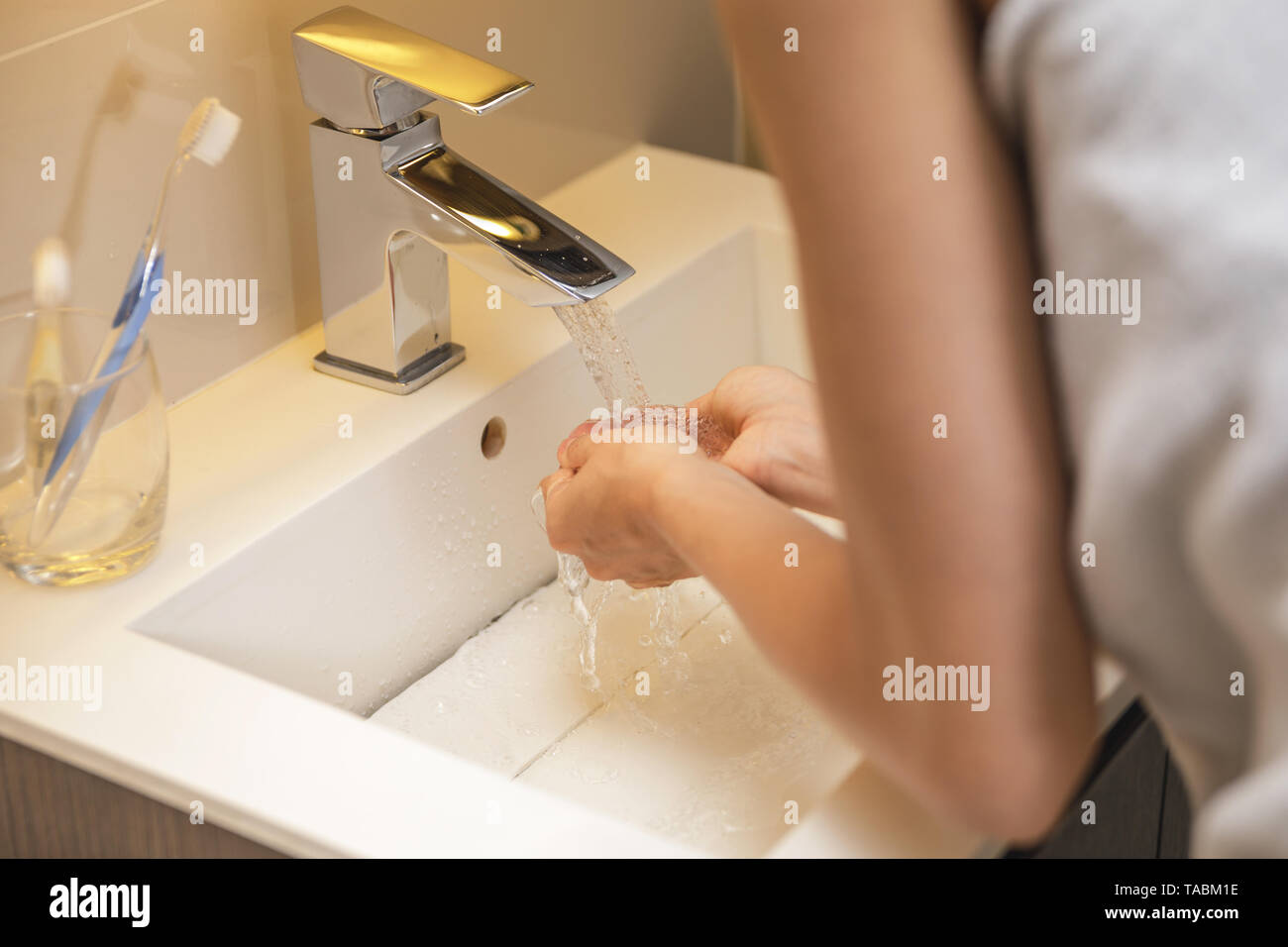 Woman washing her hands under the tap Stock Photo - Alamy