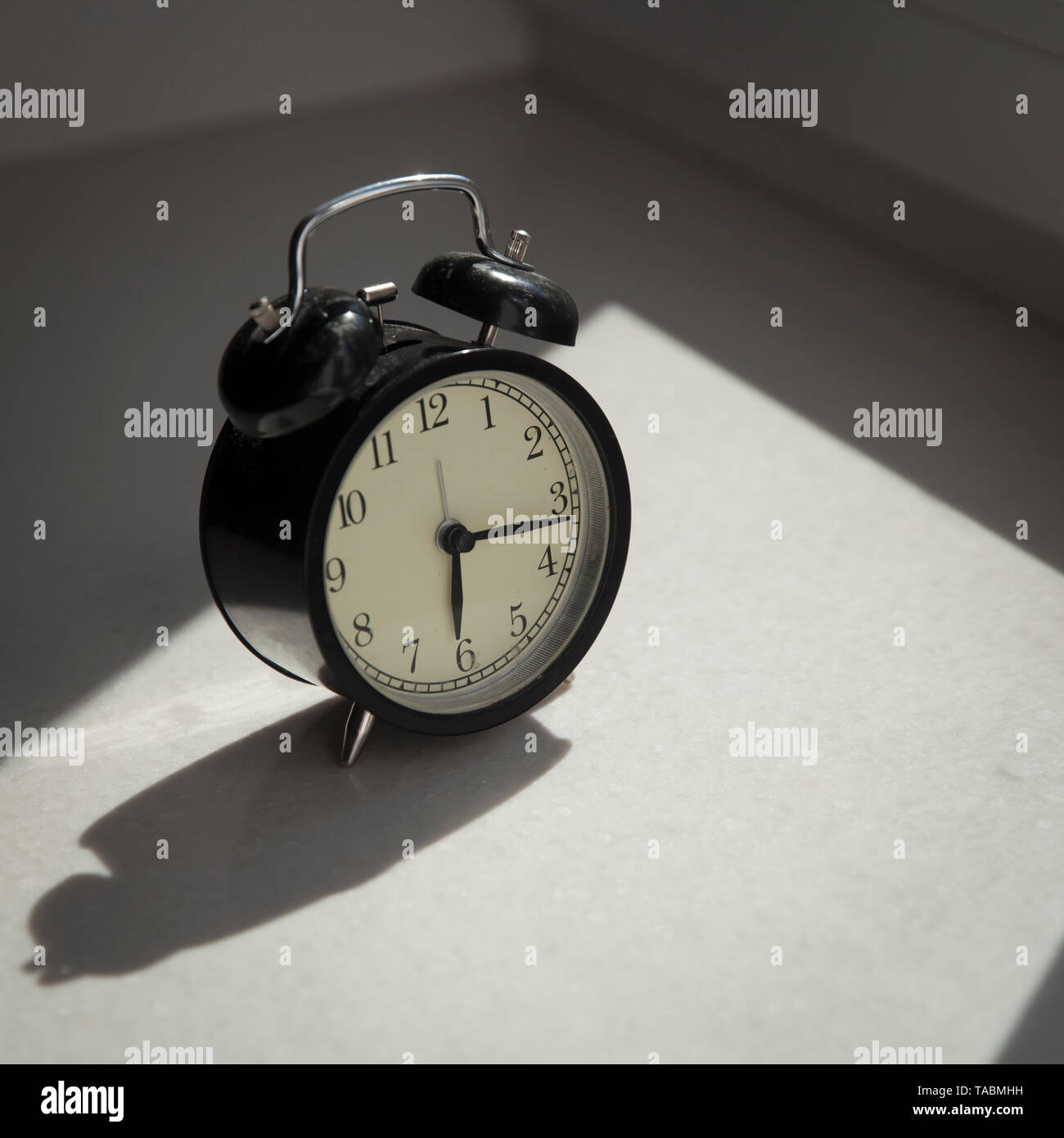 The alarm clock is on the window. It shows time at a quarter to six ...