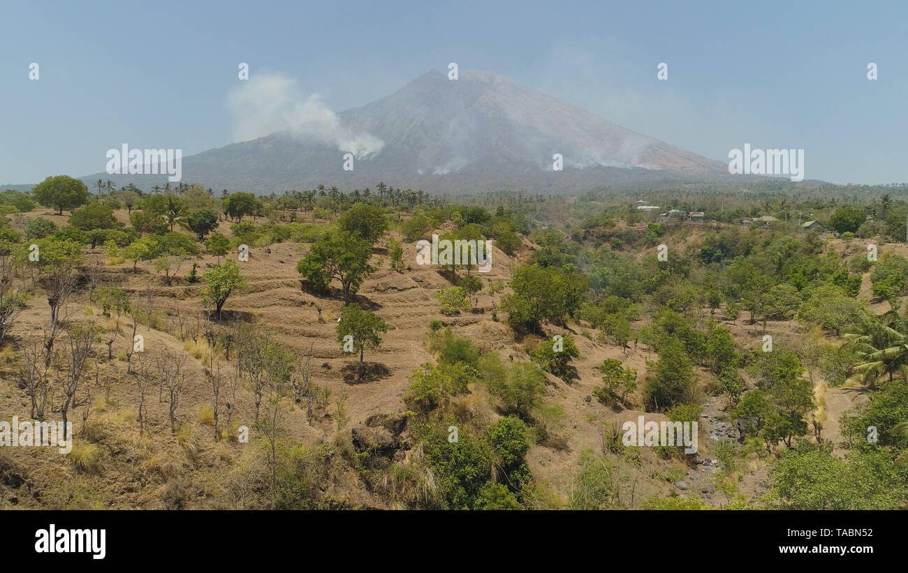 slopes volcano with forest fire, farmland at foot of the volcano Agung ...