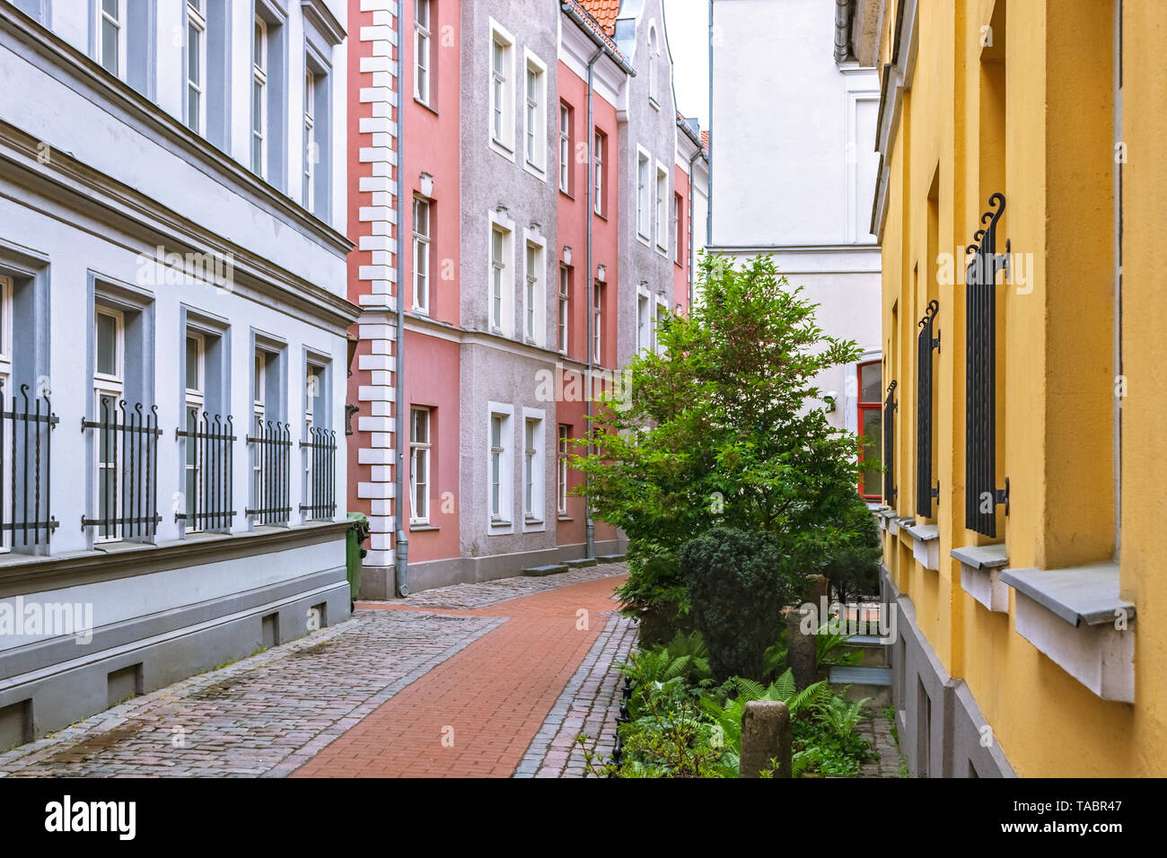 A quiet pedestrian street of old Riga with a pavement paved with red ...