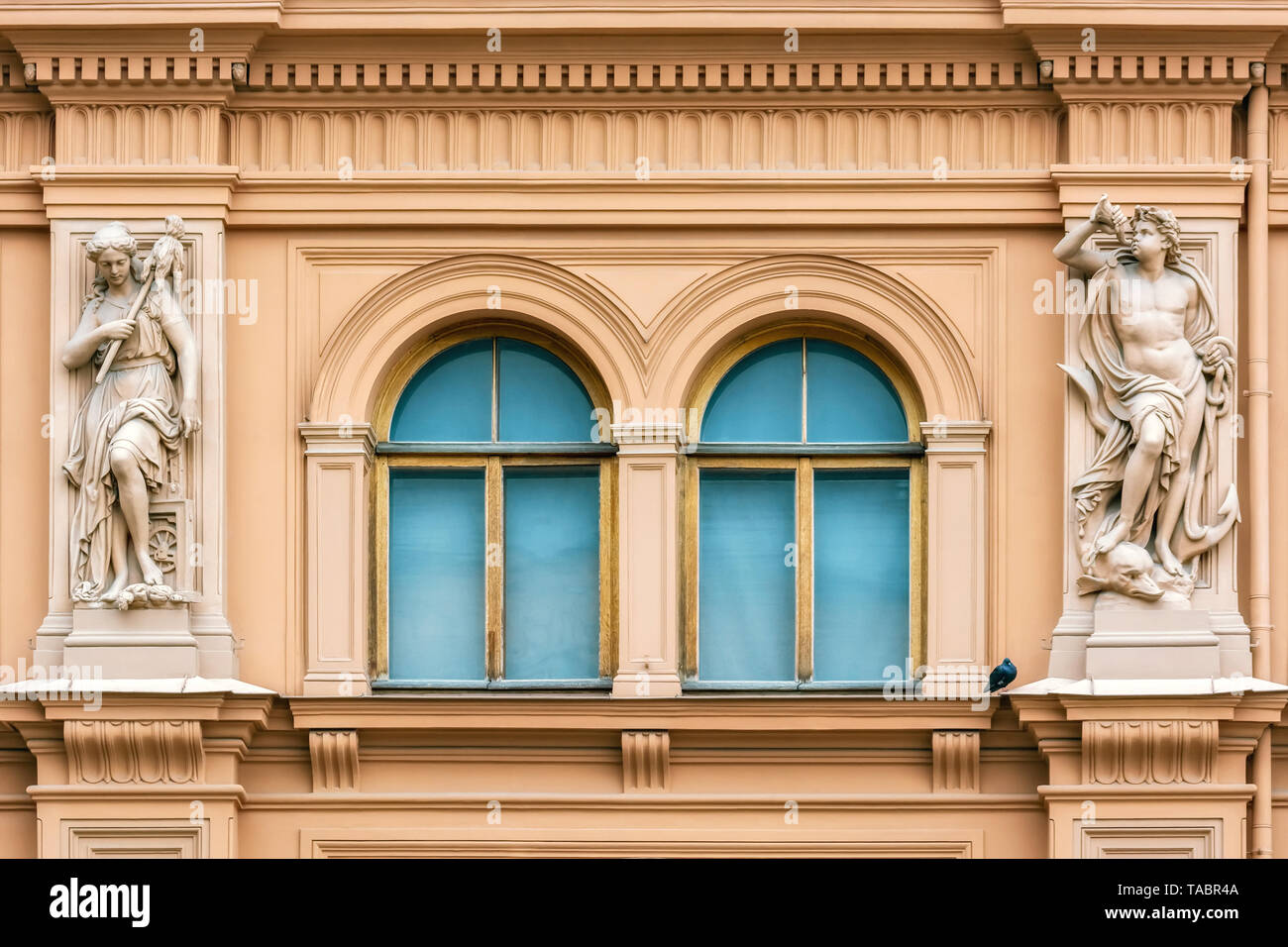 Two arched Windows with wooden frames against a beige wall with stucco ...