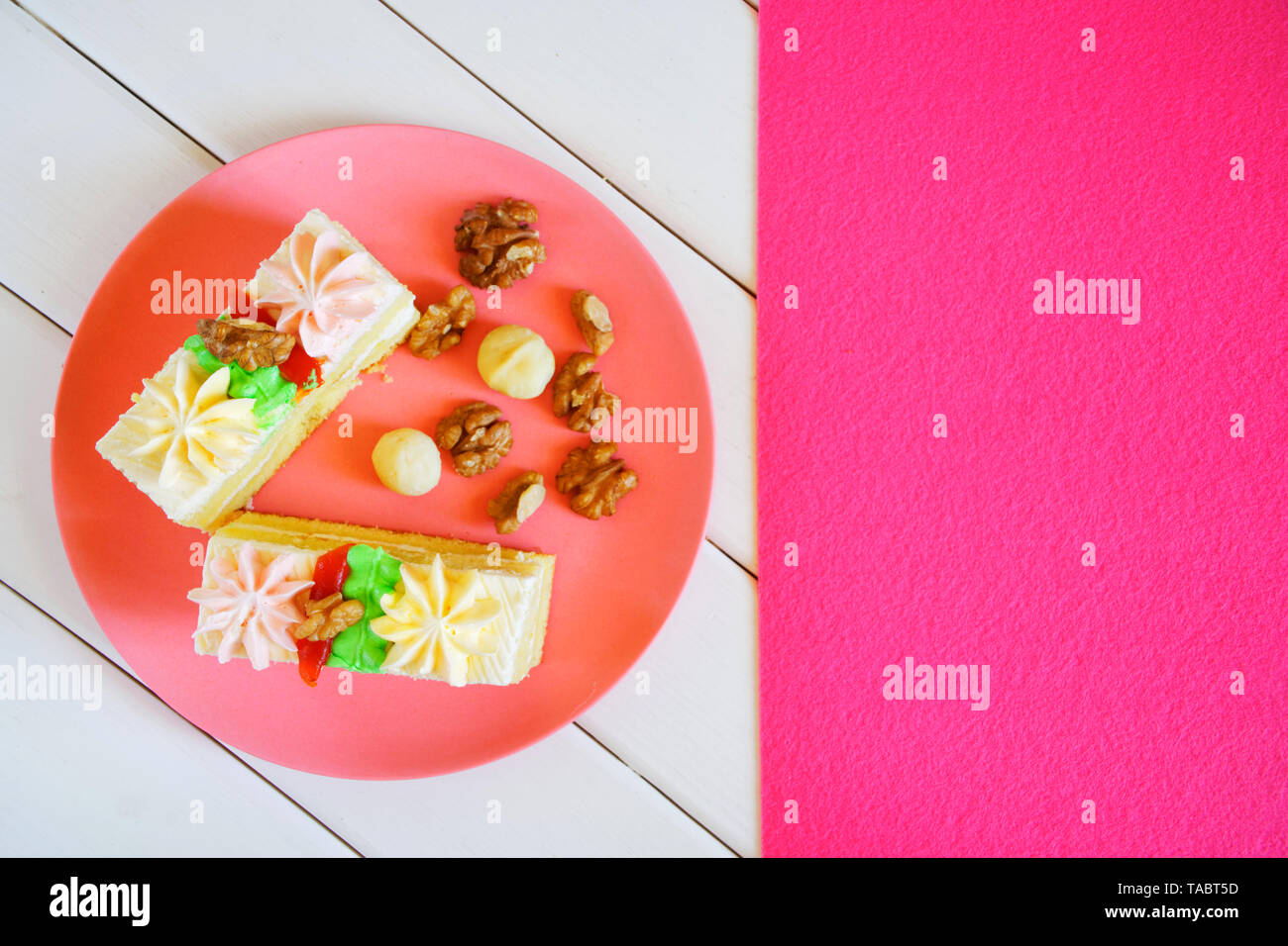 Slices of sponge cake with cream decorations, macadamia nuts and ...