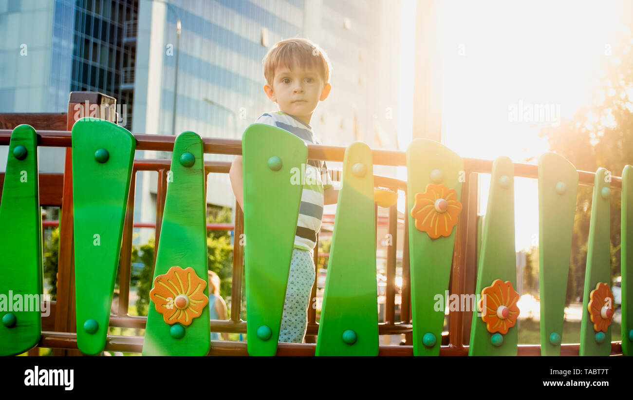 Portrait of 3 years old little boy walking and crawling on high wooden ...
