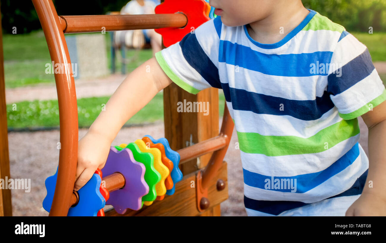 Closeup image of little boy playing on the playground and rotating ...