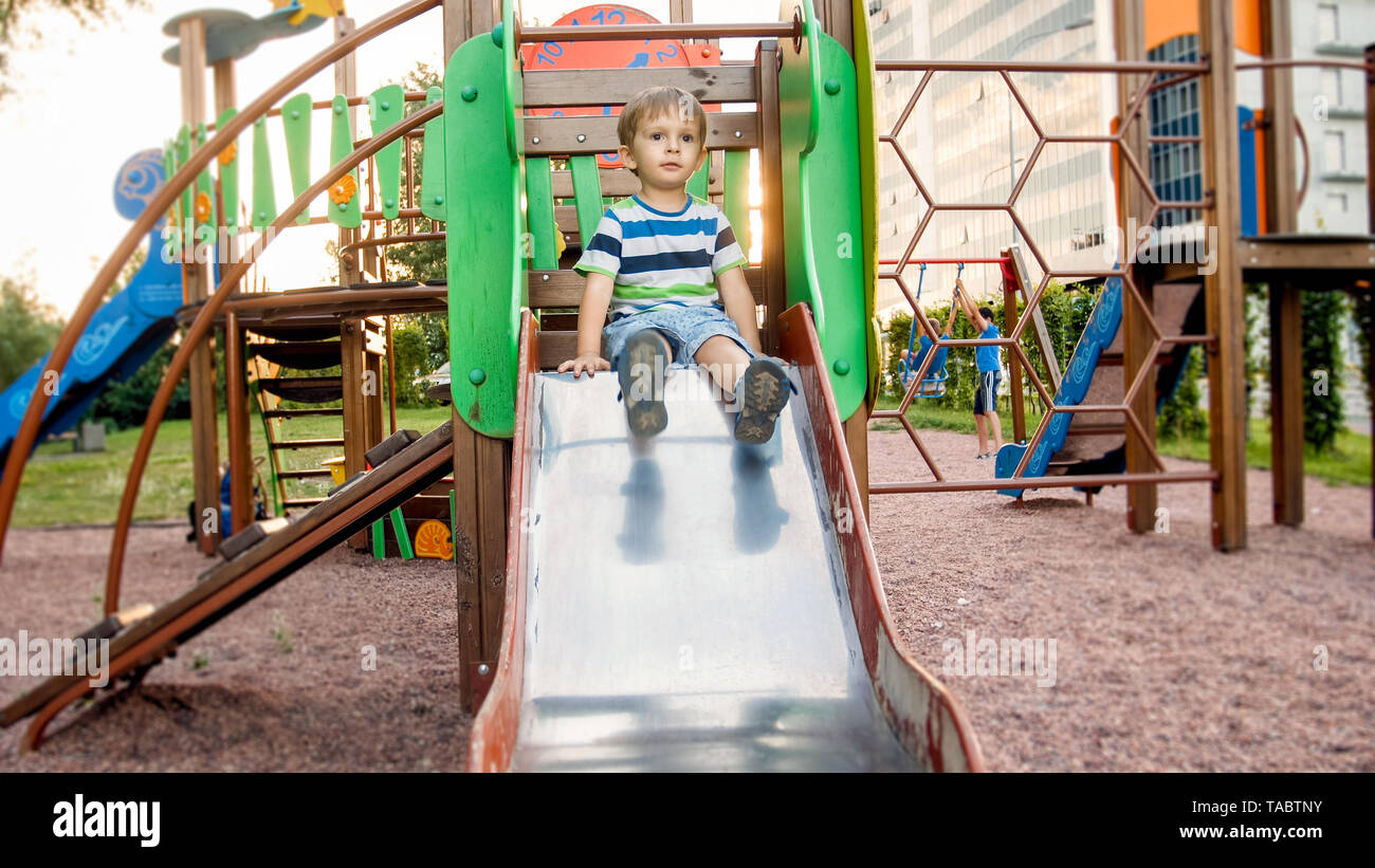 Image of happy smiling cheerful toddler boy riding and climbing on the ...