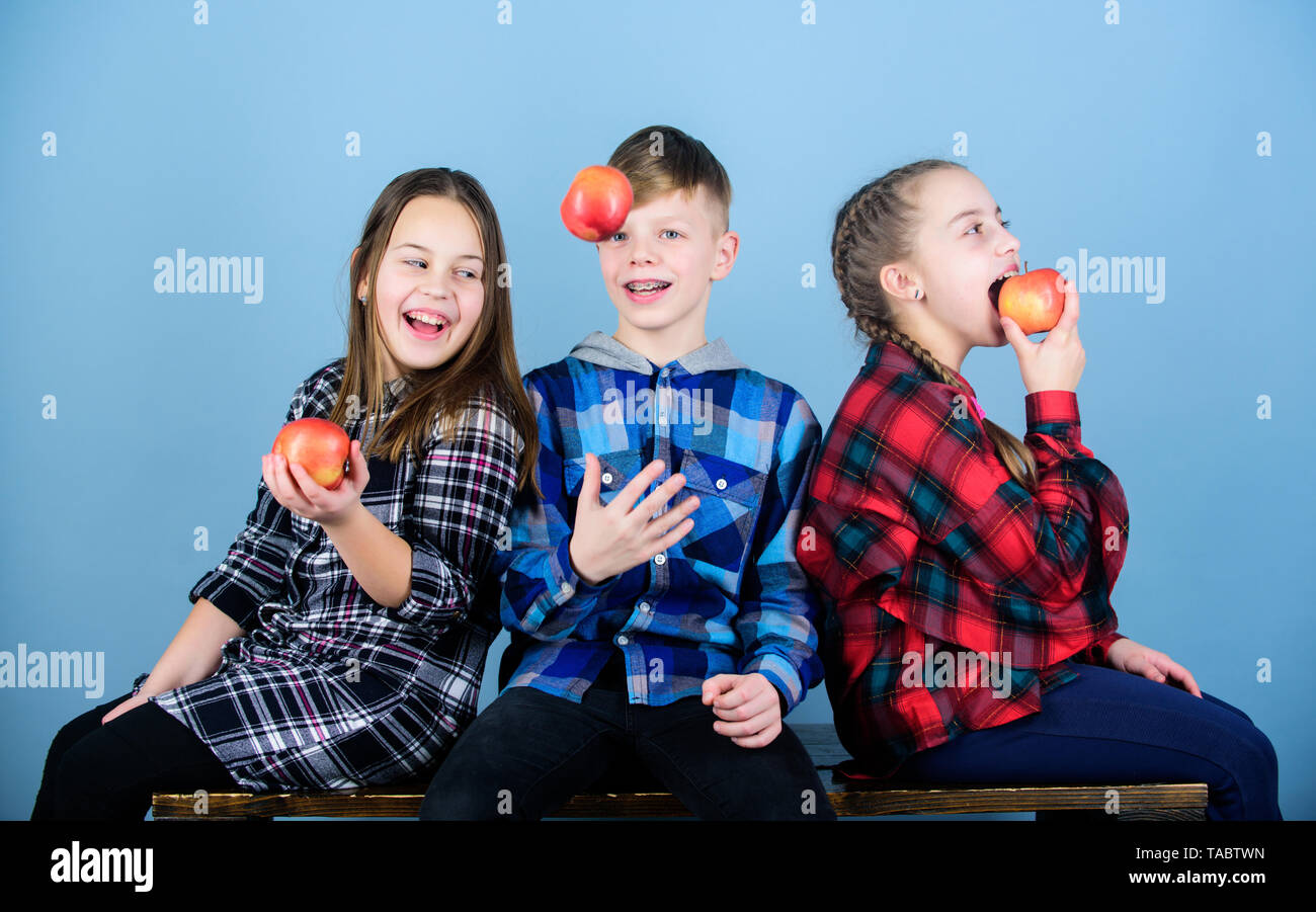 Boy and girls friends eat apple snack while relaxing. Teens with ...