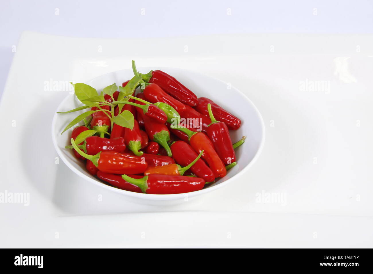 Red chili on paper white background Stock Photo - Alamy