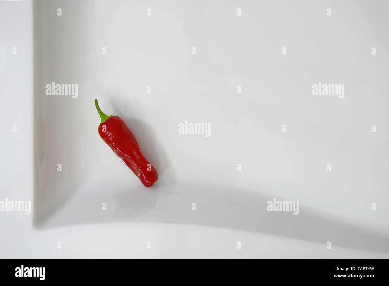 Red chili on paper white background Stock Photo - Alamy