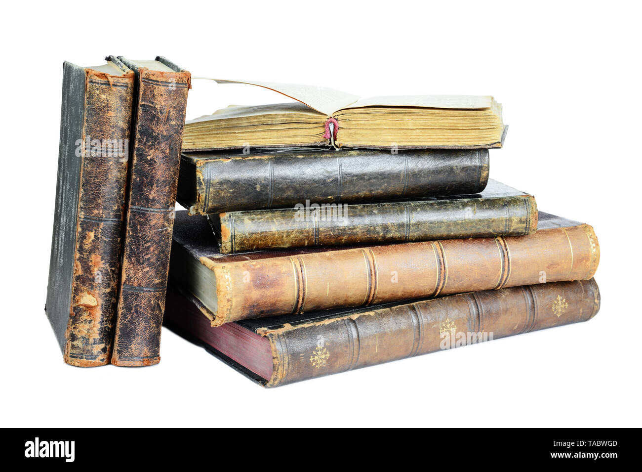 Open book lies on a pile of old books isolated on a white background ...