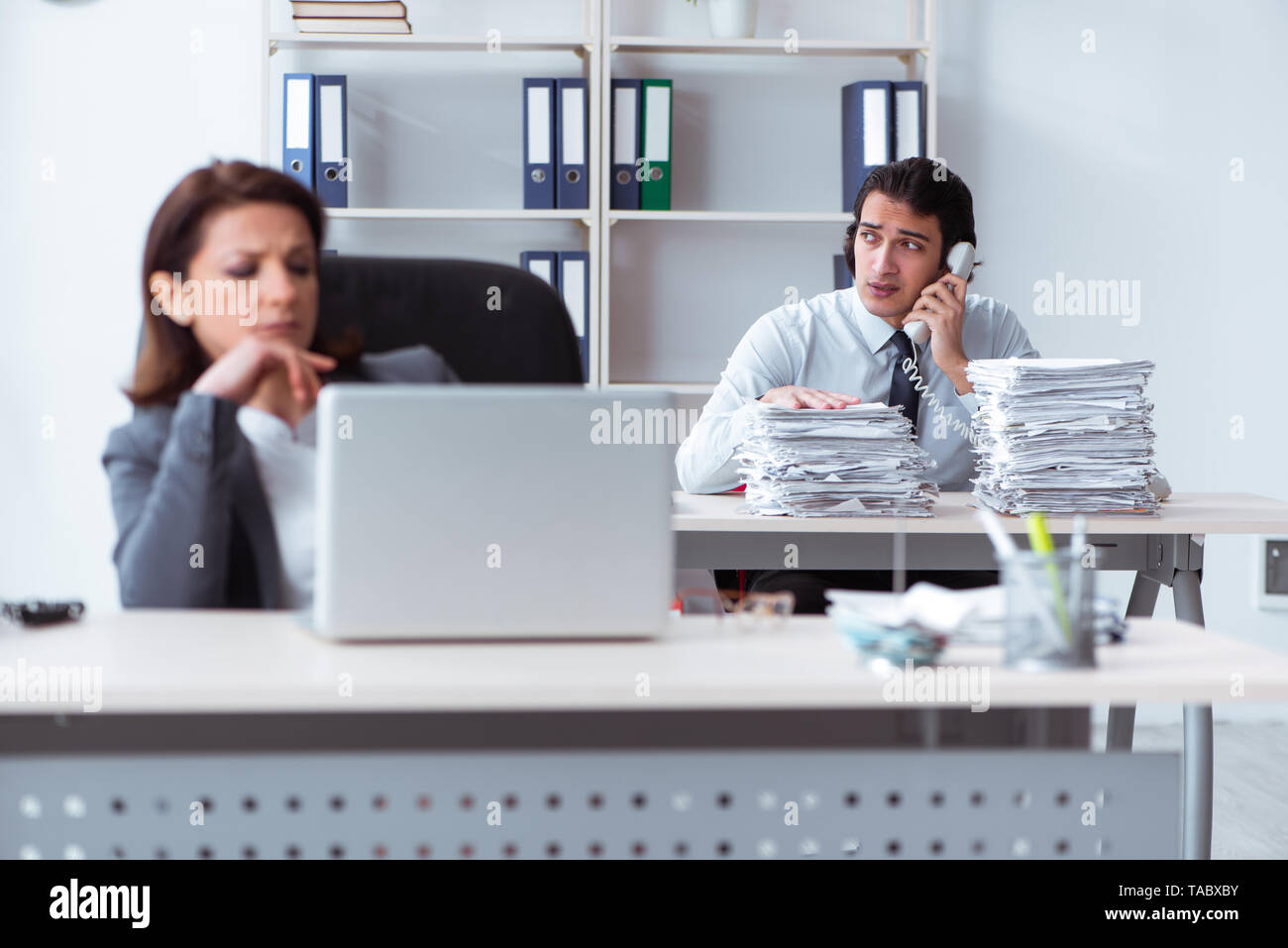 Old female boss and young male employee in the office Stock Photo - Alamy