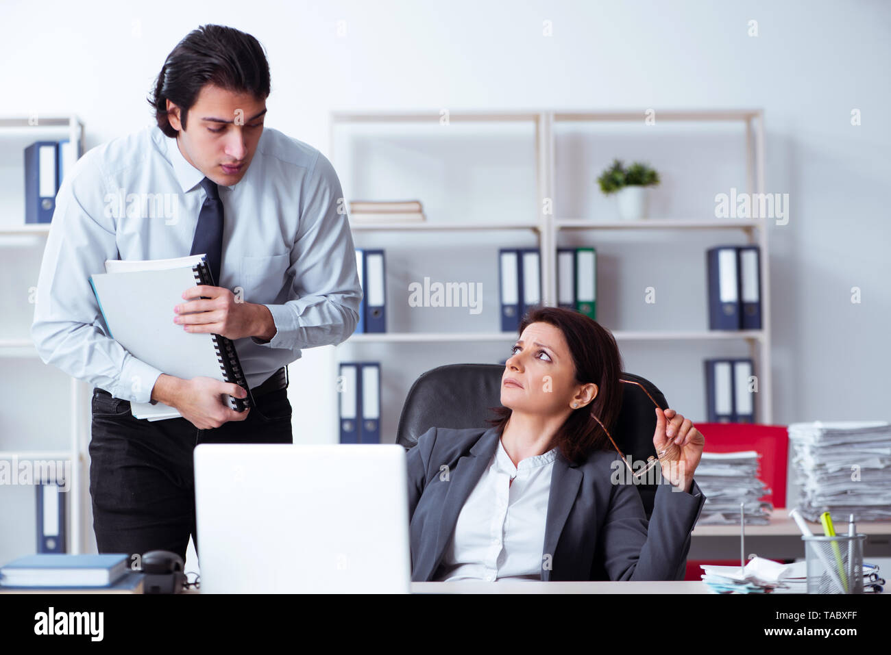 Old female boss and young male employee in the office Stock Photo - Alamy