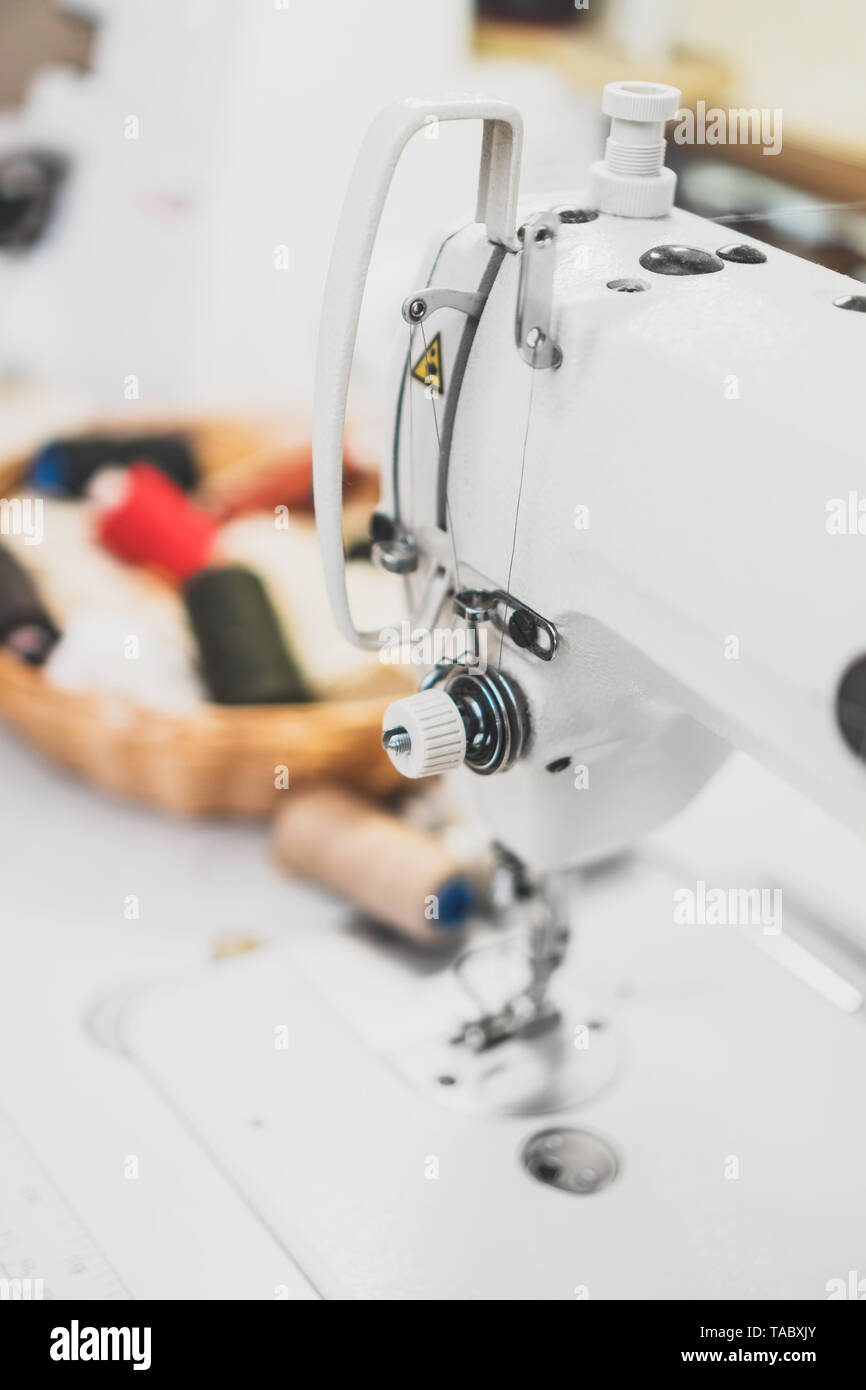Sewing concept. Sewing machine and spool threads Stock Photo - Alamy