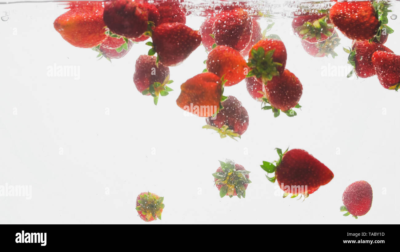 Closeup isolated image of lots of fresh ripe raspberries falling and ...