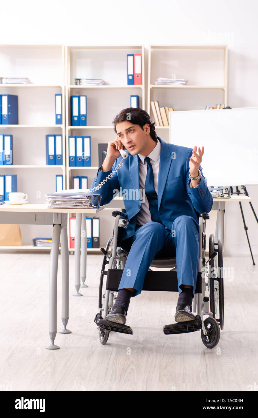 Male employee in wheelchair working at the office Stock Photo - Alamy